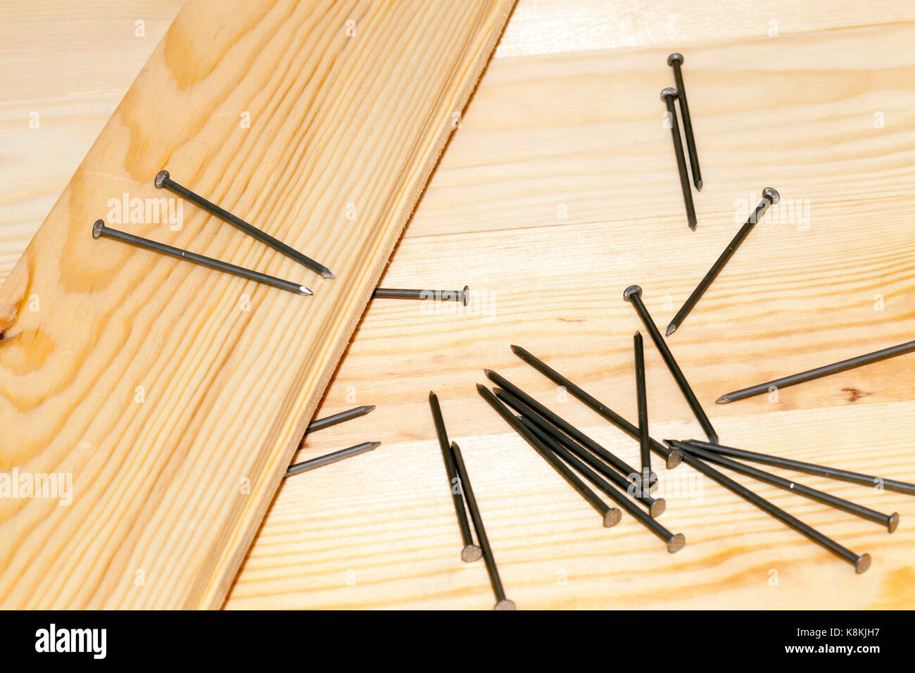 Steel nails, lying on wooden boards for floor construction. photo close ...