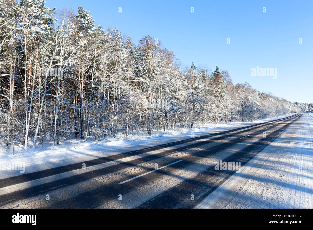photo of a diagonal asphalt road covered with snow in winter. landscape ...