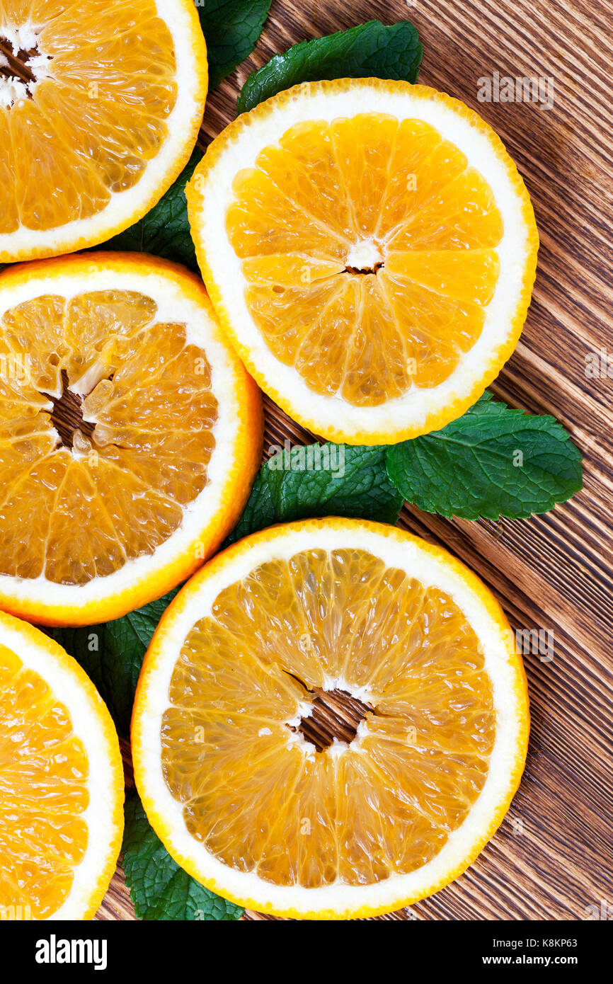 close-up photo of an orange cut into slices. Pieces of fruit lie on an ...