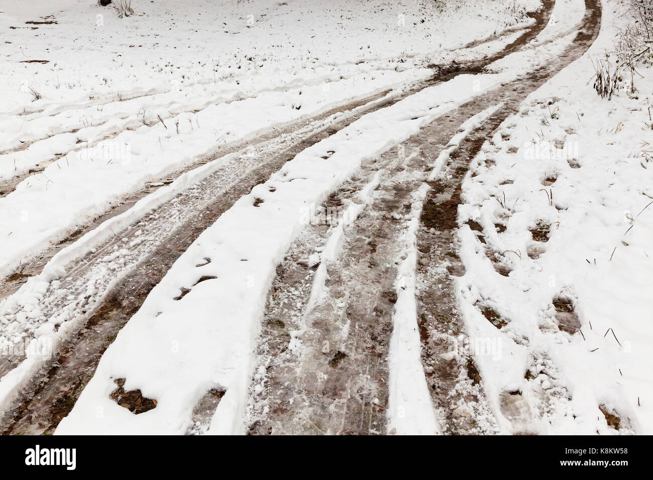 tracks from the wheels of the car on a rural road covered with snow ...