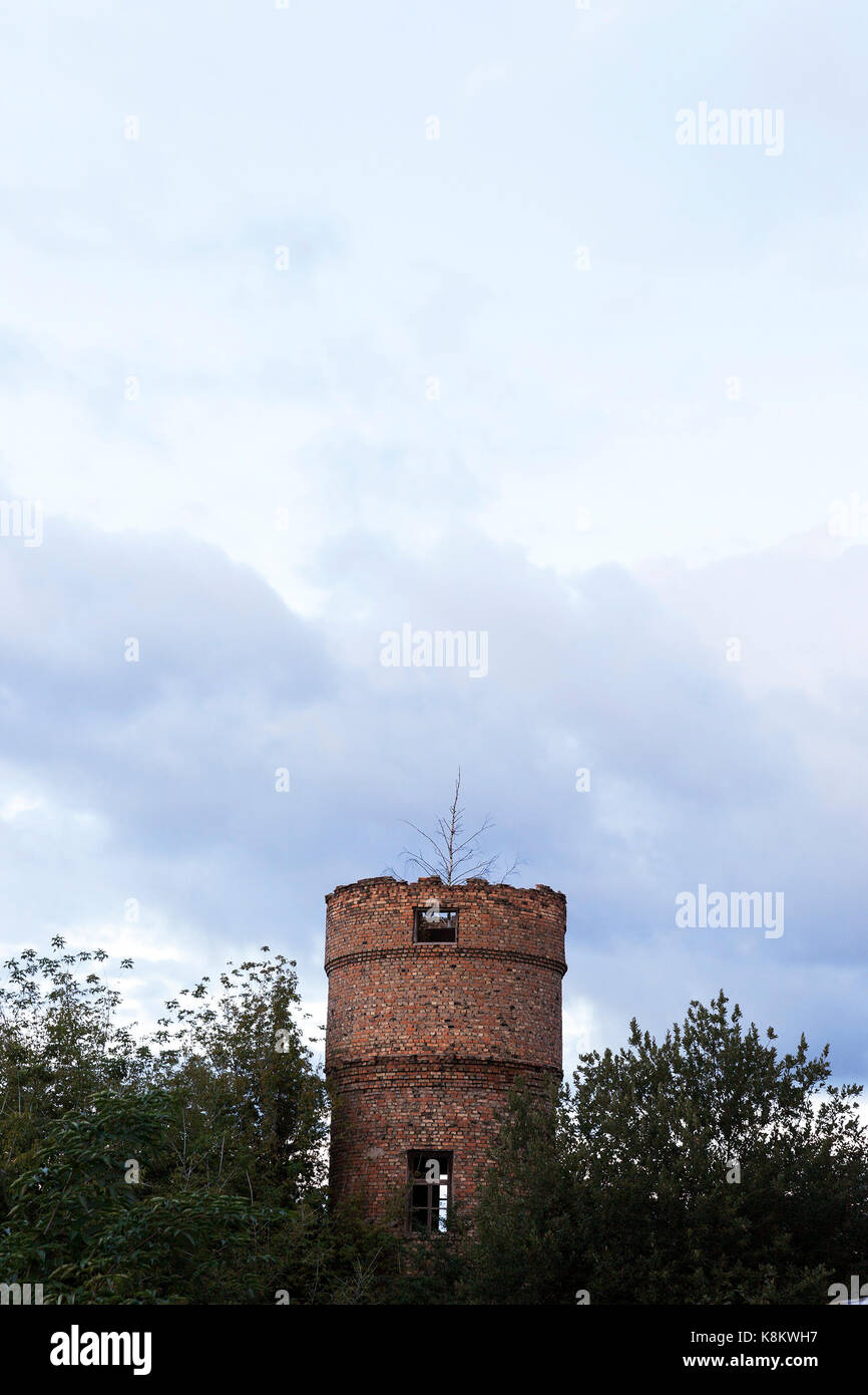 close-up photograph of an old water tower, made of bricks. blue sky ...