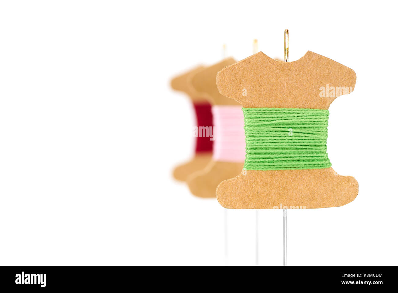 Needle, thread and kraft card bobbin on white background Stock Photo ...