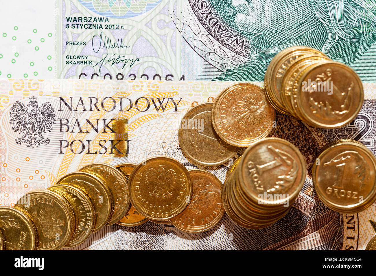 several Polish coins lying on paper currency signs of Poland ...