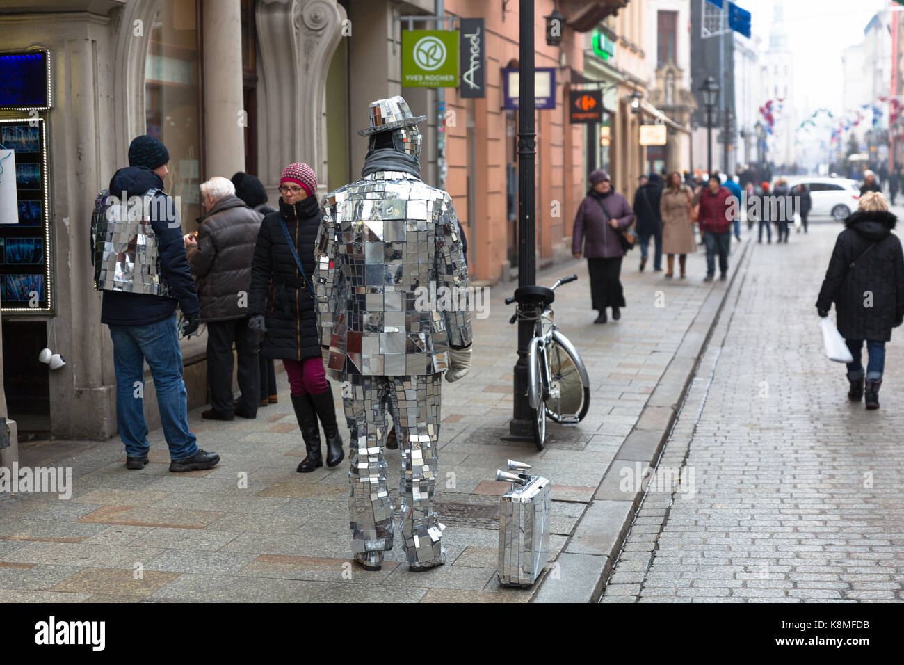 Street performer dressed in silver on sidewalk in Krakow Main Square ...