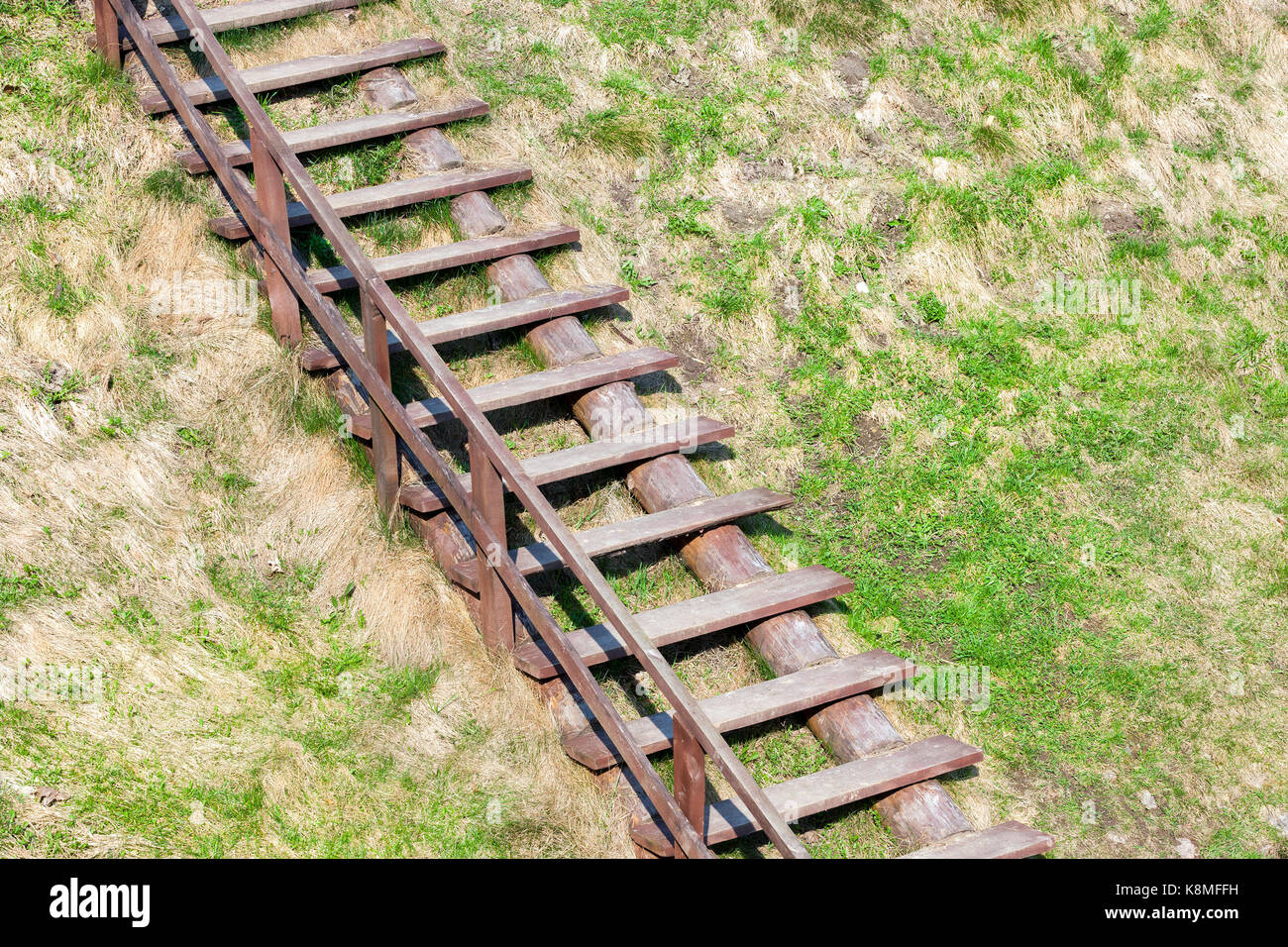 wooden staircase on a hill. Green grass growing around the stairs ...