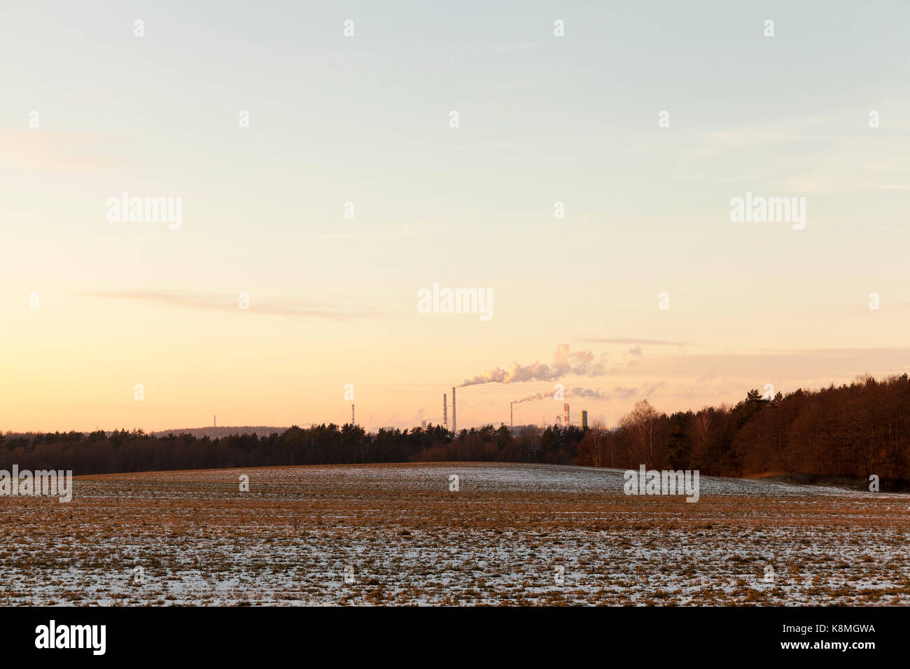 smoke from the pipes of the plant. winter landscape at sunset time ...