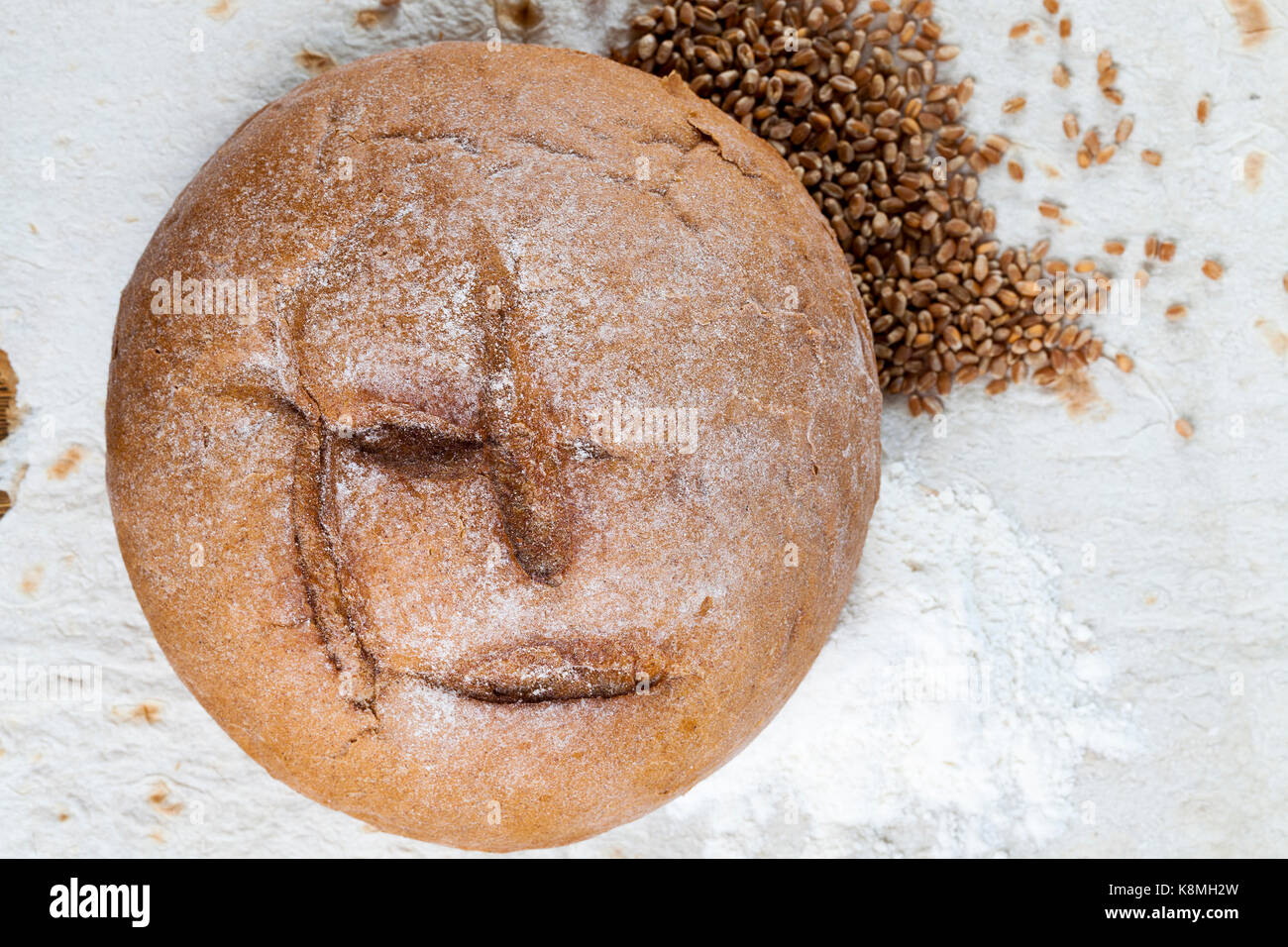 a loaf of freshly baked rye bread, lying on a thin wheat pita bread ...
