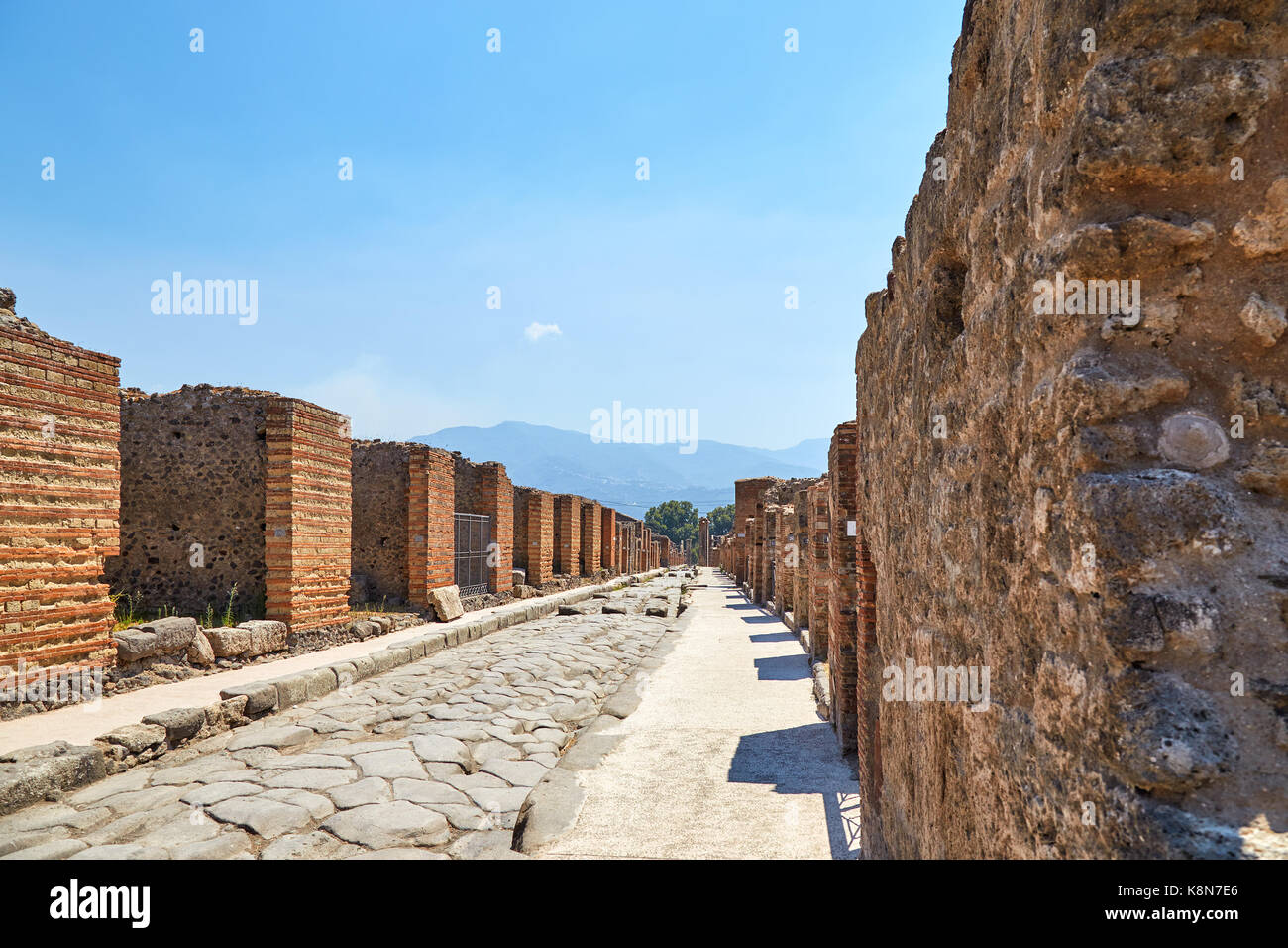 A street without people with the ruins of houses in Pompeii with ...