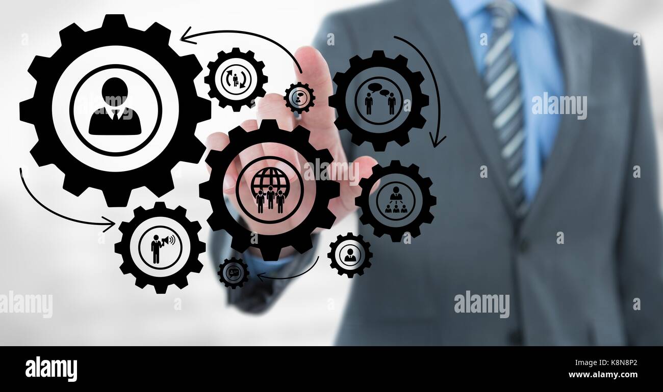 Digital composite of Business man interacting with people in cogs ...