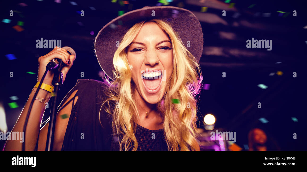 Flying colours against portrait of cheerful female singer performing at ...