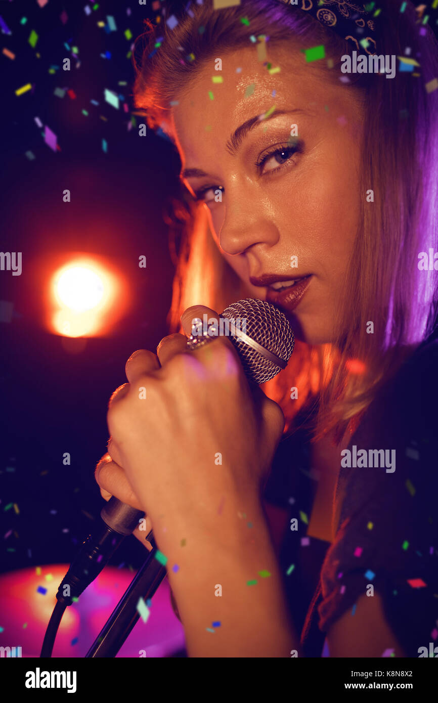 Flying colours against portrait of beautiful female singer performing ...