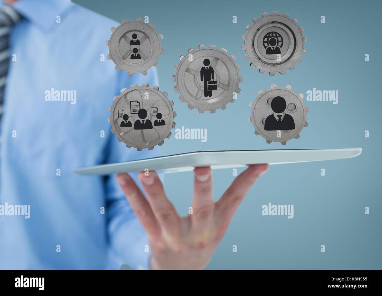 Digital composite of Business man interacting with people in cogs ...