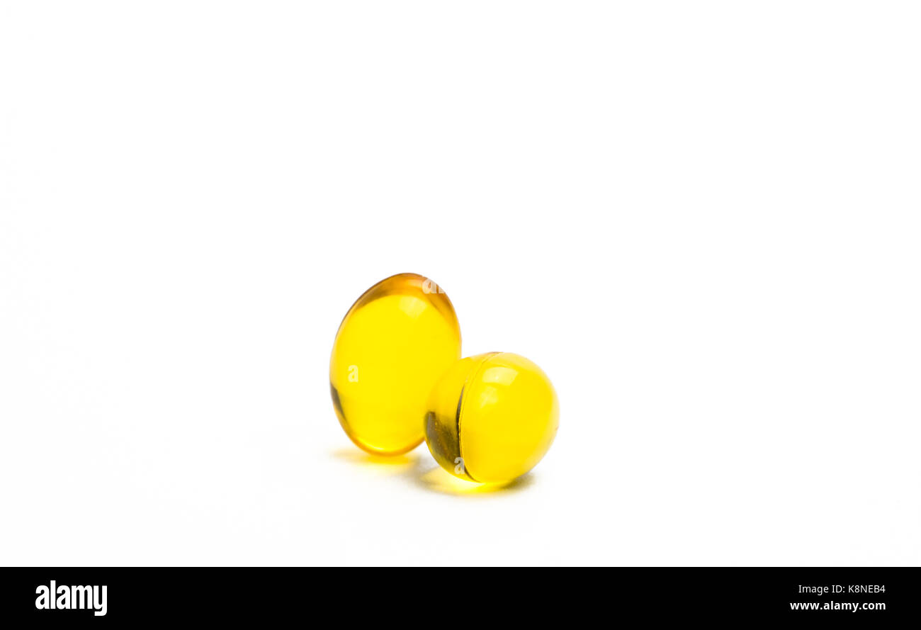 Two capsules of cod liver oil isolated on white background. Source of ...