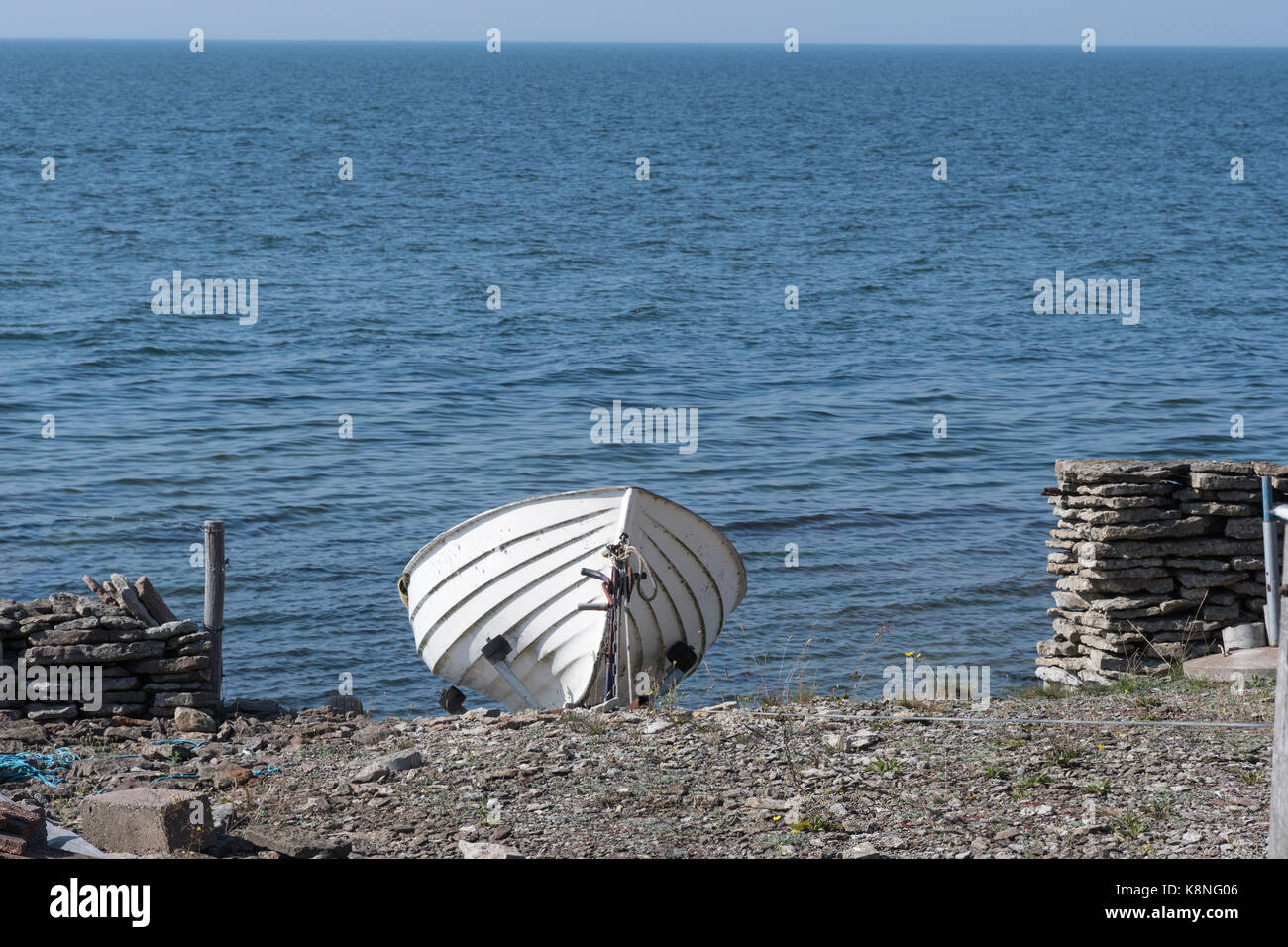 Landed white row boat by seaside Stock Photo - Alamy