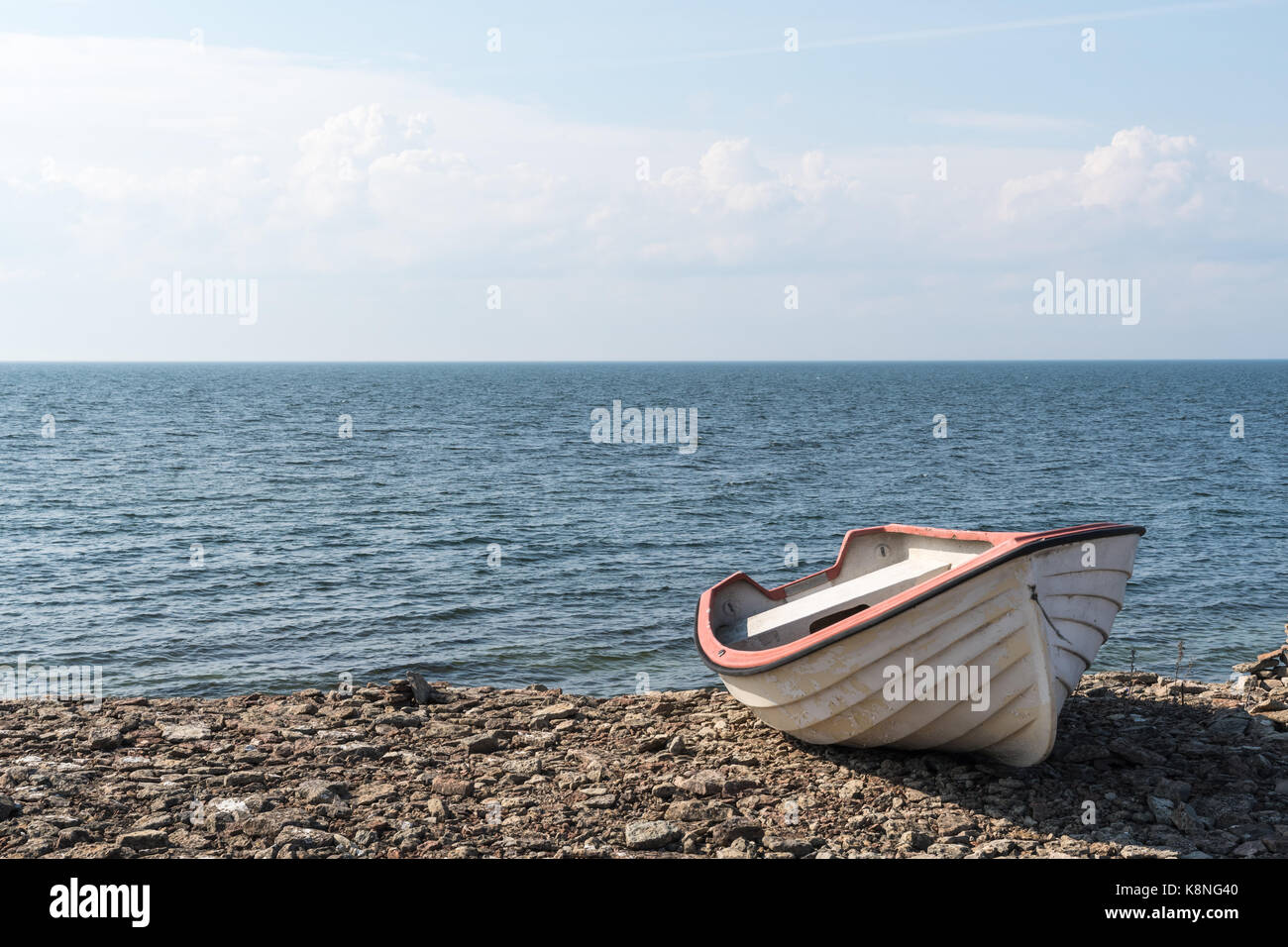 Small white rowing boat by a stony coast at the swedish island Oland ...