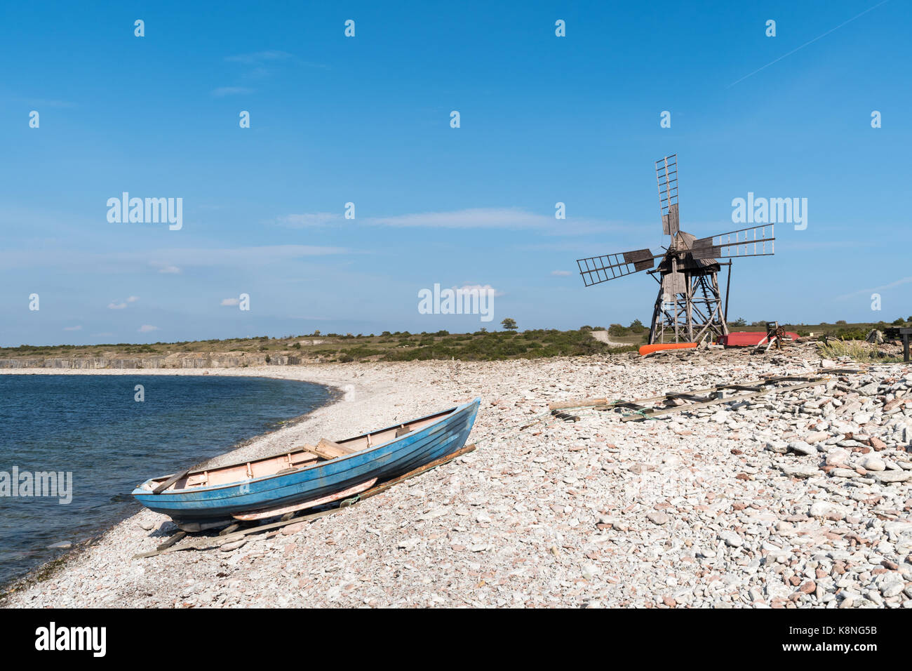 Blue rowing boat and an old windmill at the swedish island Oland in the ...