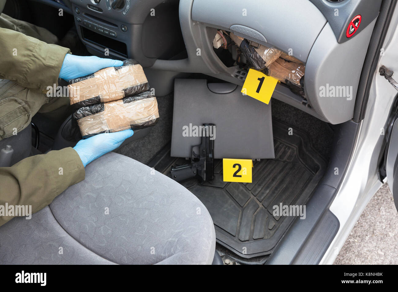 Policeman holding drug packages discovered in secret compartment of the ...