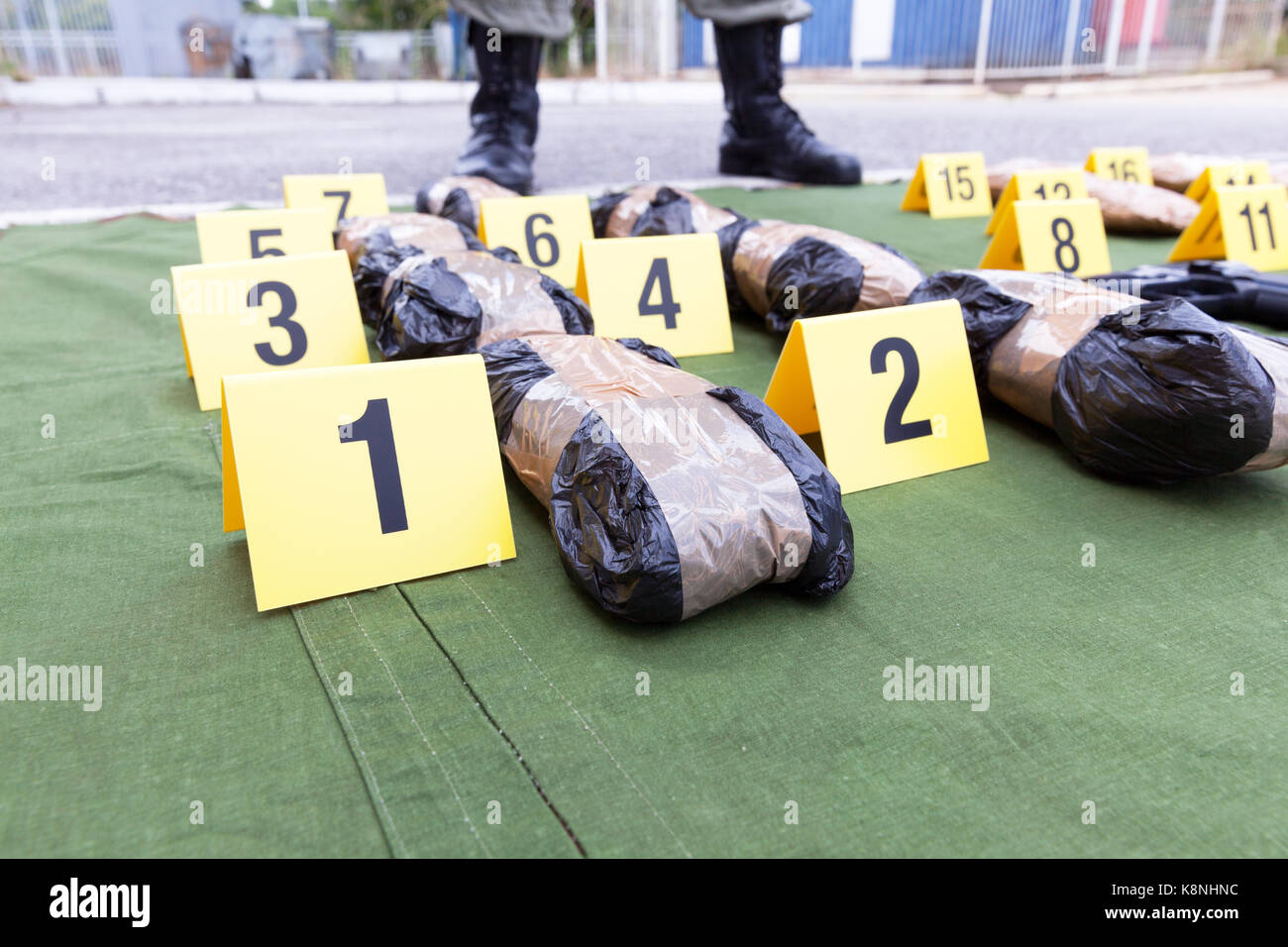 Police officer standing guard over seized packages of drug Stock Photo ...