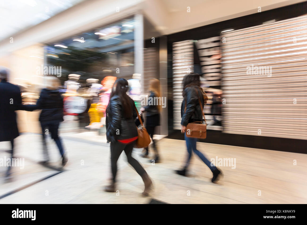 Shopper walking in front of shop window Stock Photo - Alamy