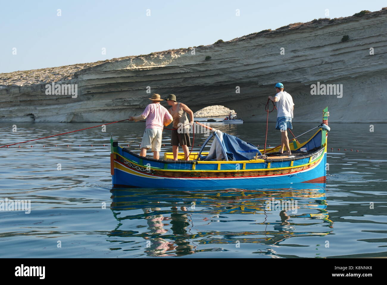 Fishing from a traditional colourful luzzu boat, Il-Hofra I-Kbira bay ...