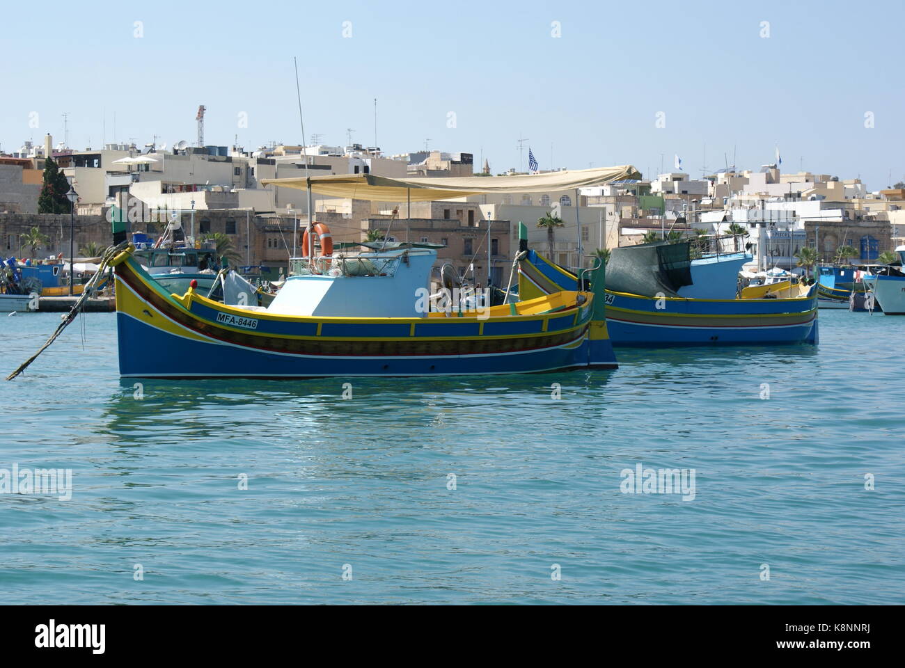 Traditional colourful luzzu boats in the fishing harbour of Marsaxlokk ...