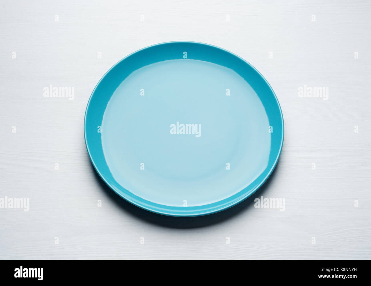 Empty blue plate on white wooden background. Top view with copy space ...