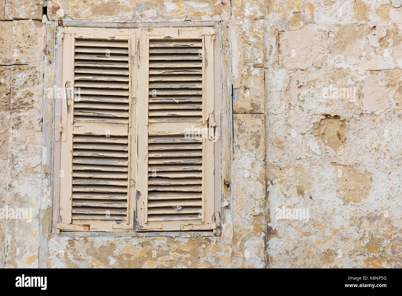 An old shuttered window on a building in Malta with peeling paint and ...