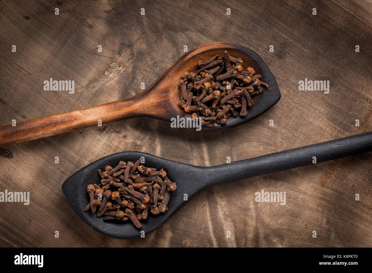 Cloves in wooden spoon on old wooden background, flat lay Stock Photo ...