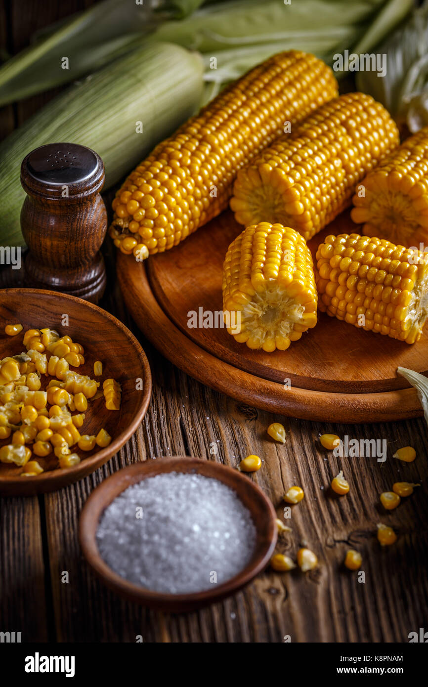 Boiled corn with salt on rustic style background Stock Photo - Alamy