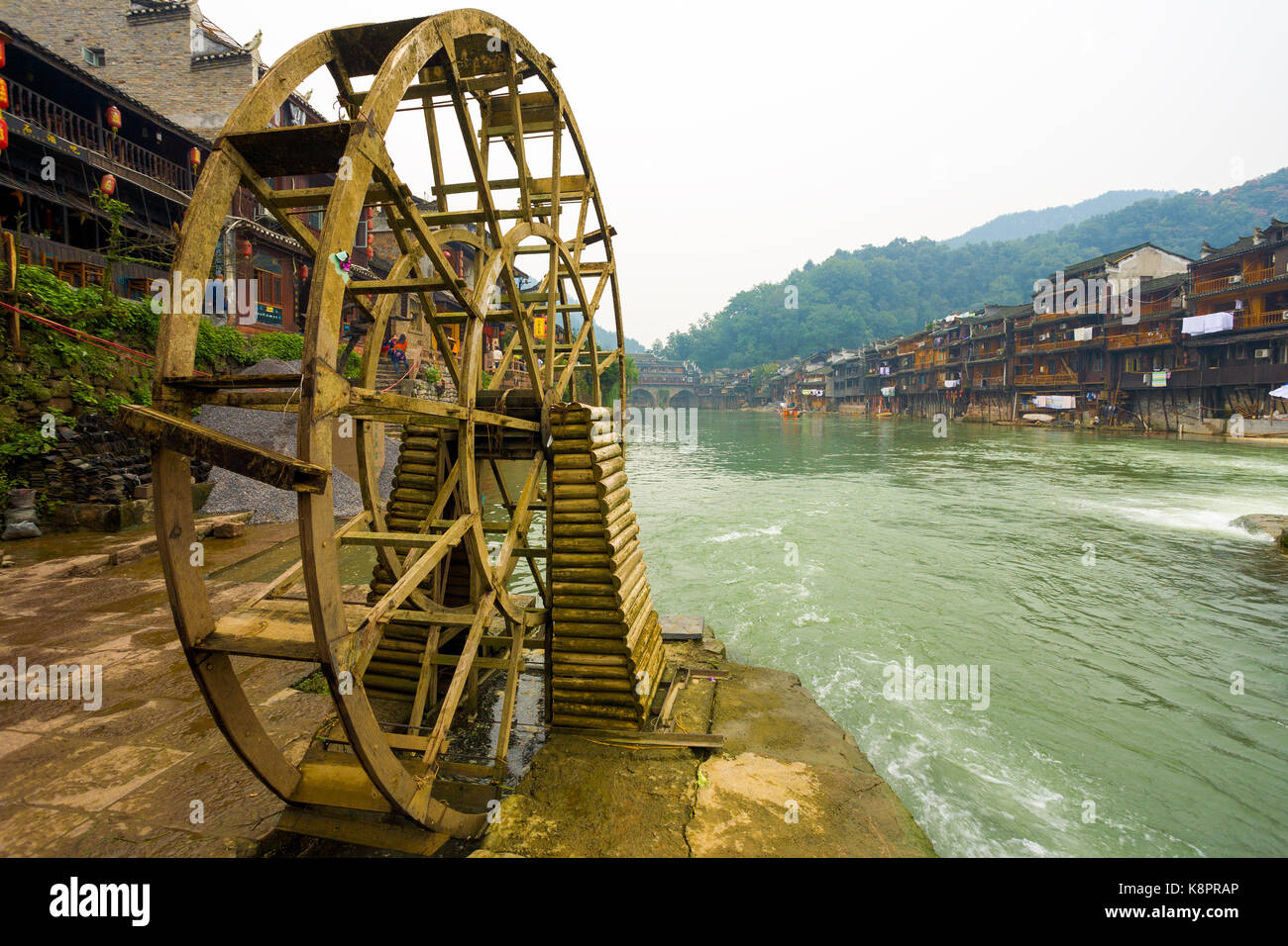 Fenghuang, China - September 10, 2007: A wooden water wheel and old ...