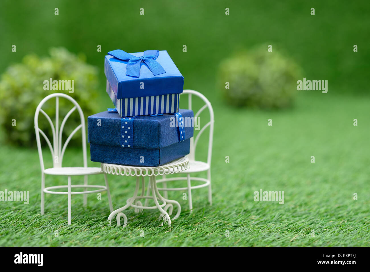 Gift box on white field chair in green garden, with copy space to write ...