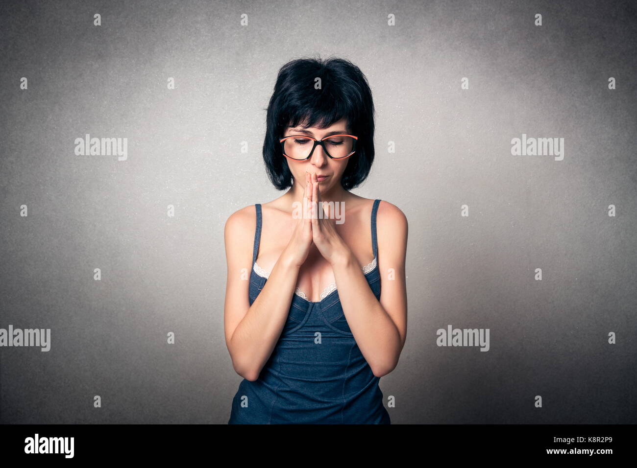 Pretty woman with praying sign Stock Photo - Alamy