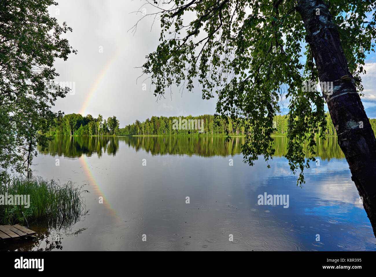 Landscape with a rainbow on the shore of a beautiful lake Stock Photo ...