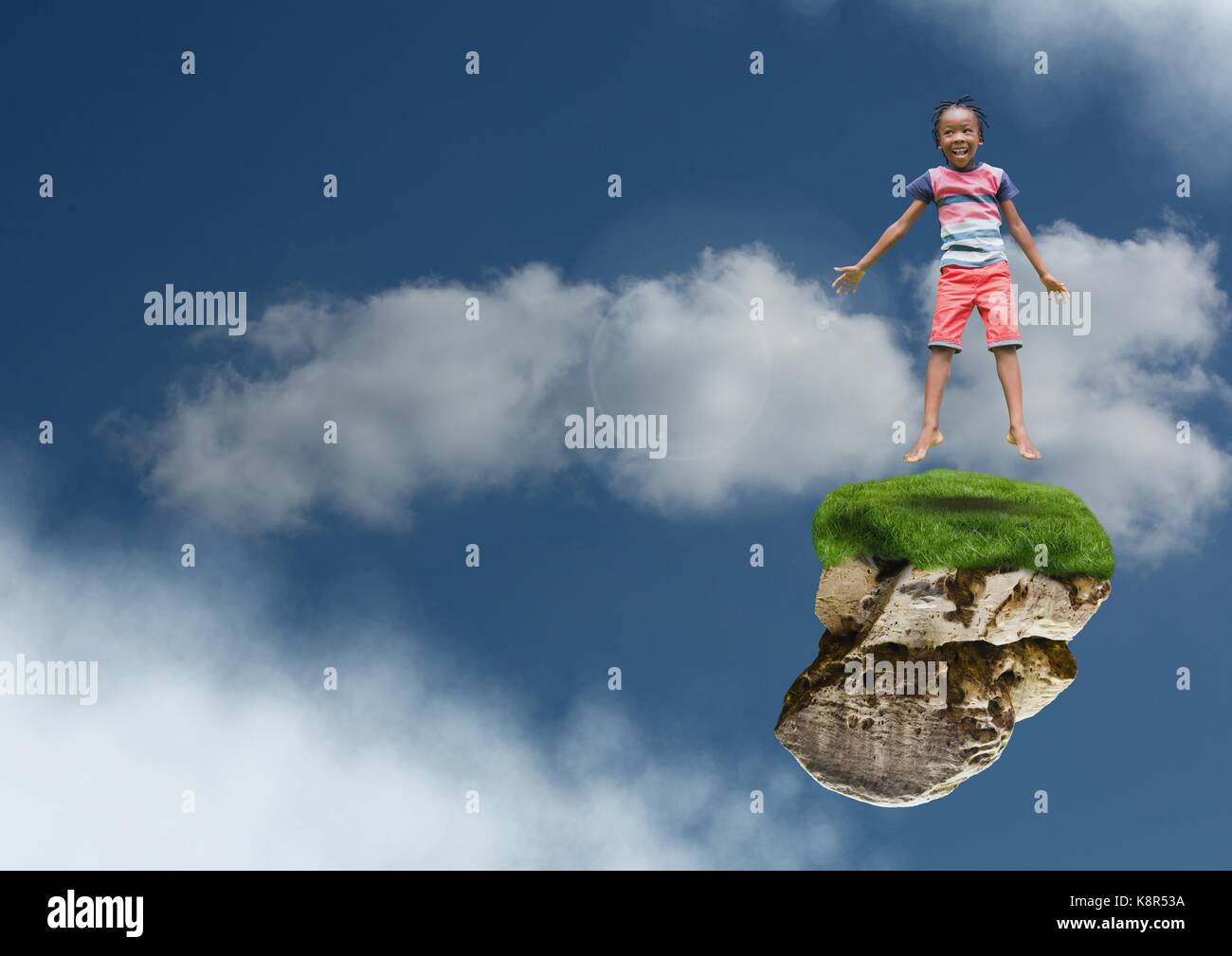 Digital composite of Young boy on floating rock platform in sky jumping ...