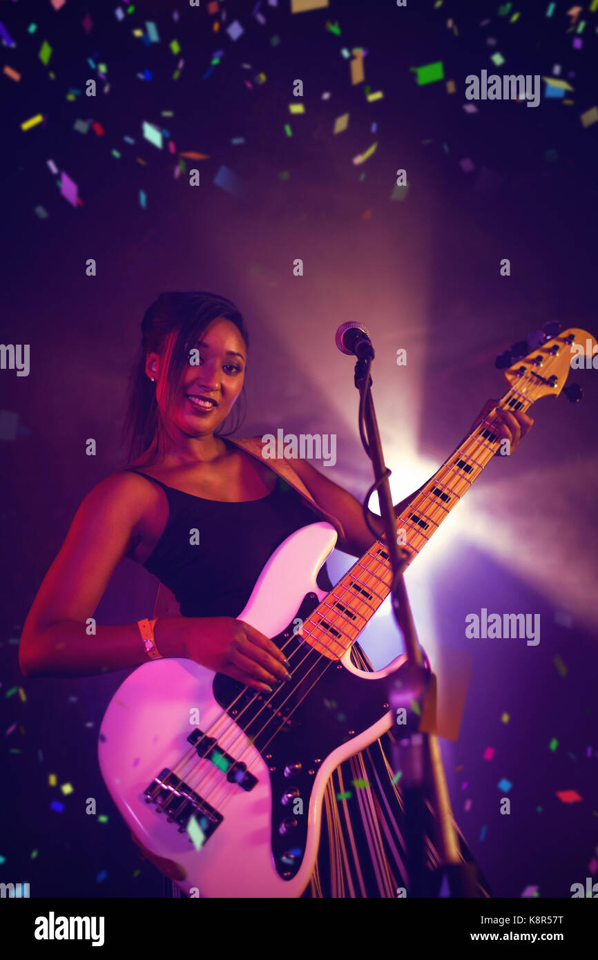 Flying colours against confident female singer holding guitar on stage ...