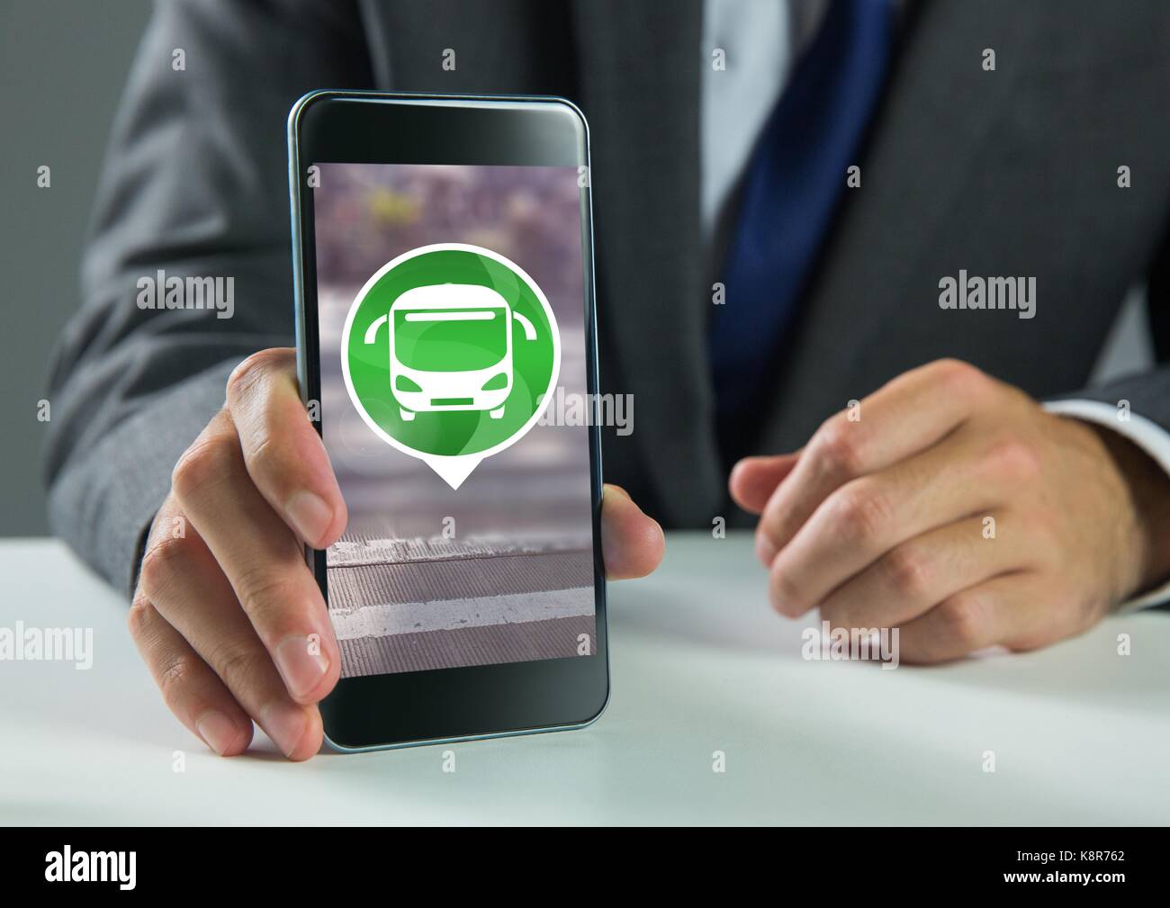 Digital composite of Hand holding phone with bus icon Stock Photo - Alamy