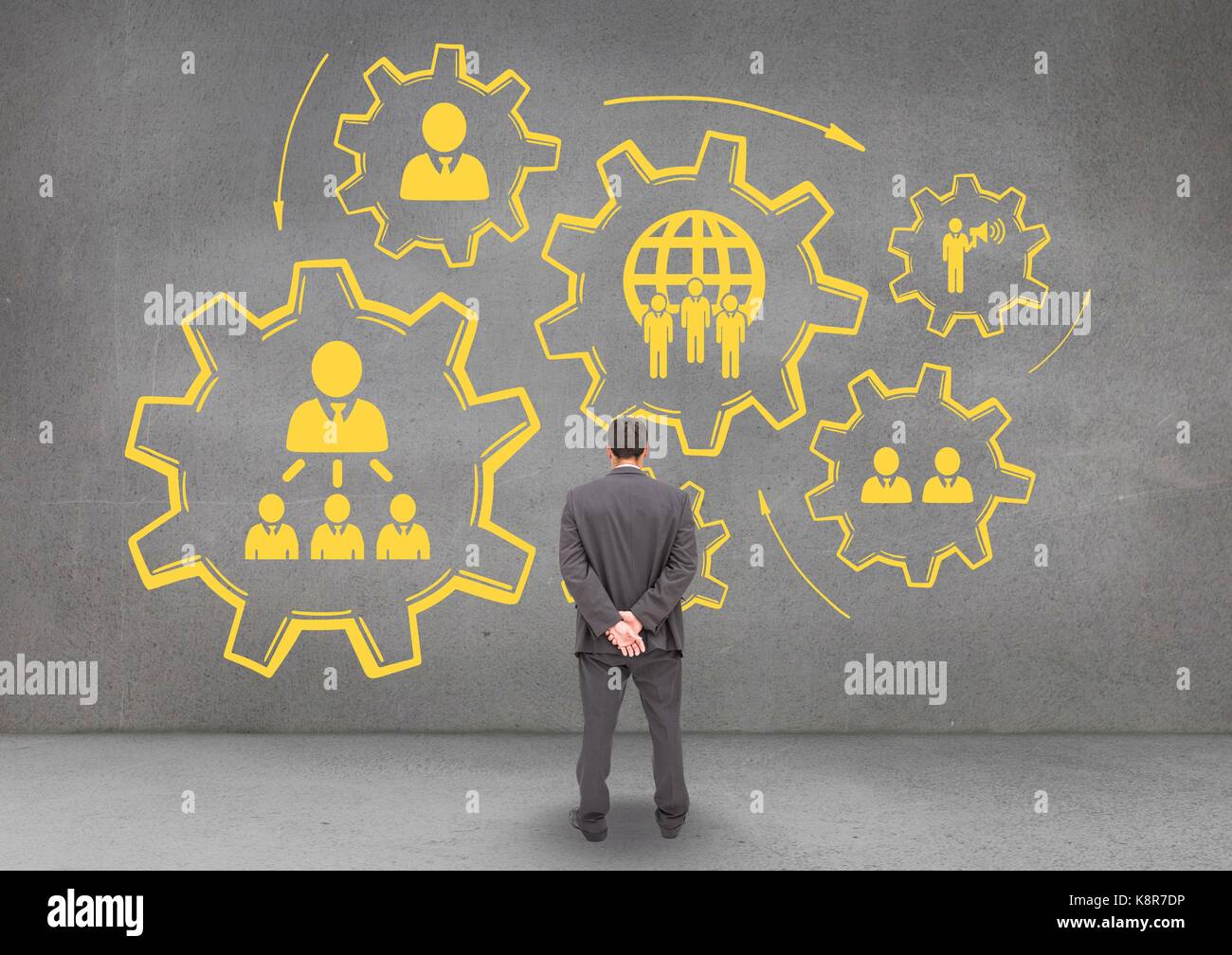 Digital composite of Business man standing against people in cogs ...