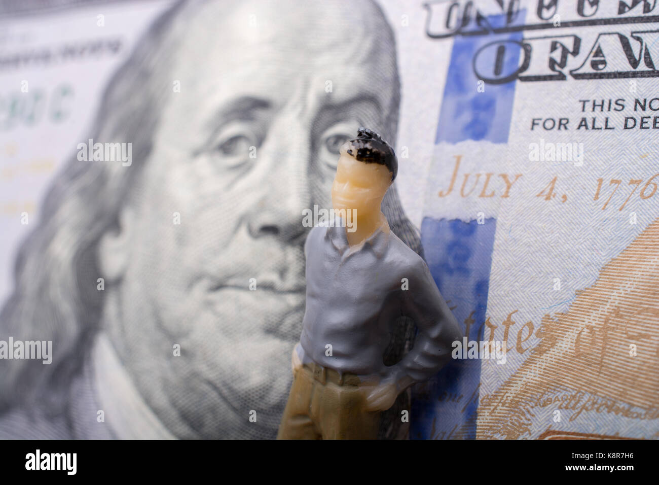 Man figurine standing beside the banknote of US dollar Stock Photo - Alamy