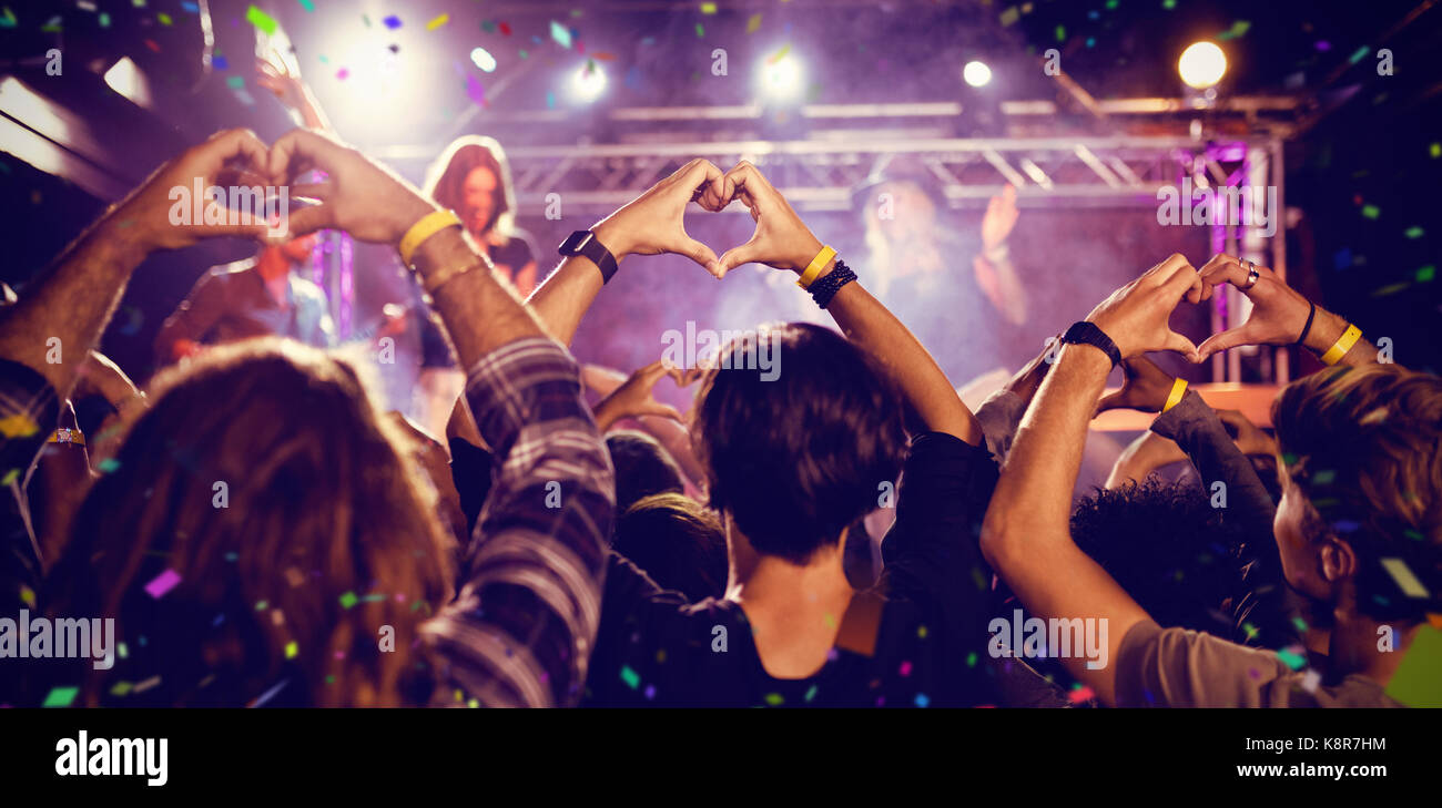Flying colours against crowd making heart shape with hands during ...