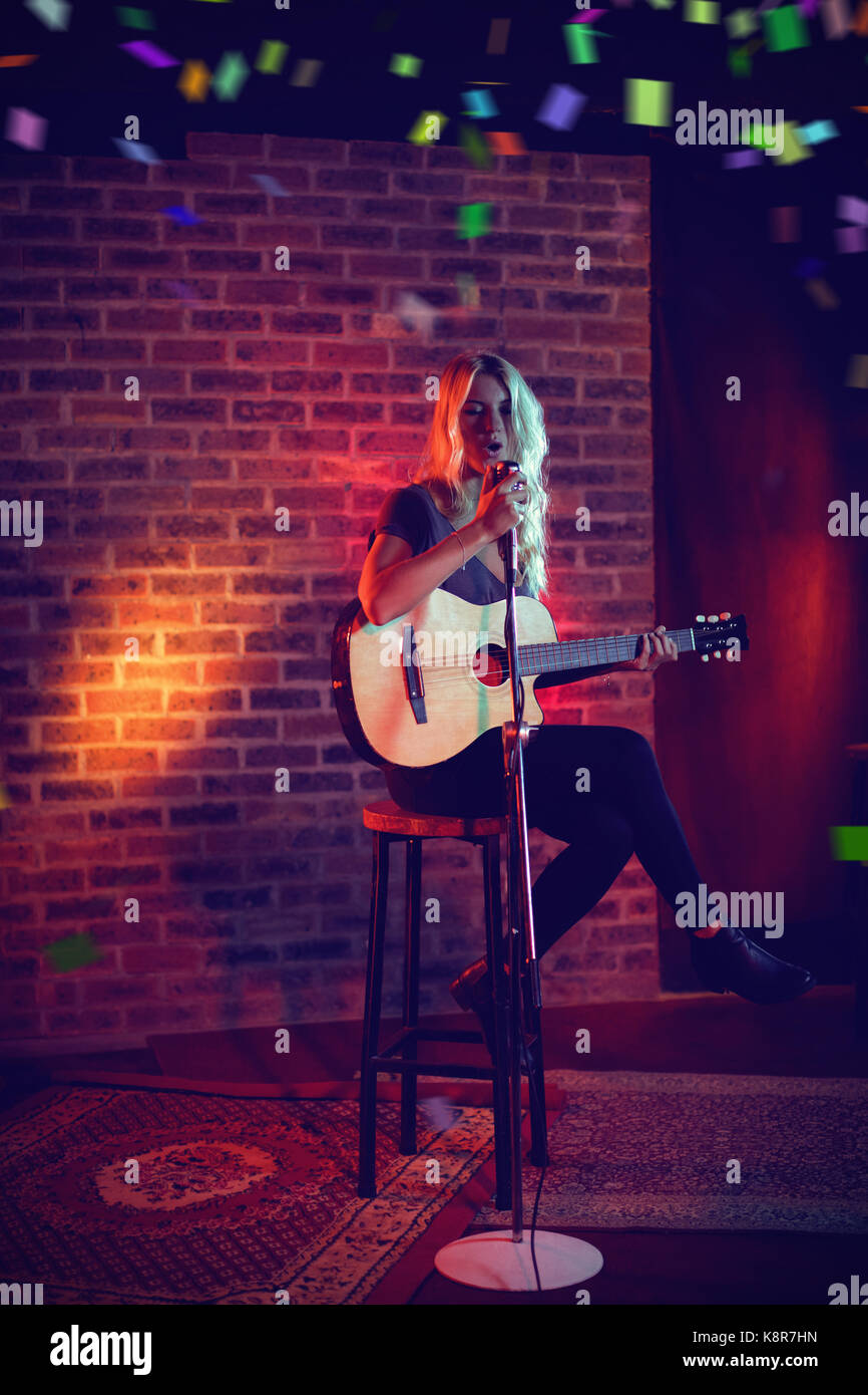 Flying colours against female singer performing illuminated nightclub ...