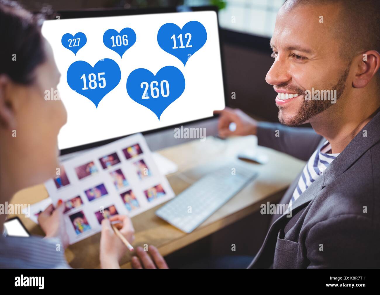 Digital composite of People working on computer in office with likes in ...