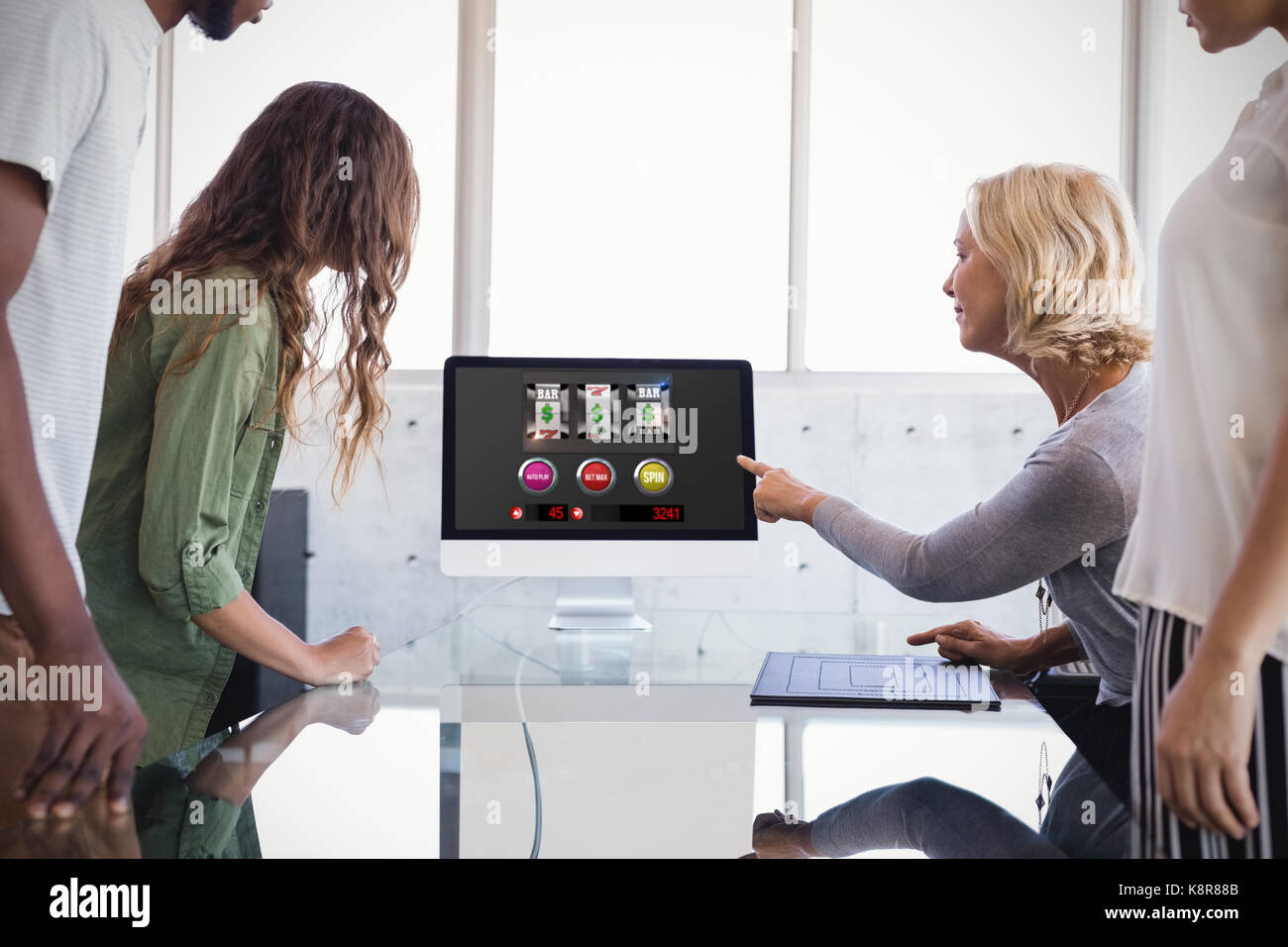 Slot machine with symbols and icons on mobile screen against colleagues ...