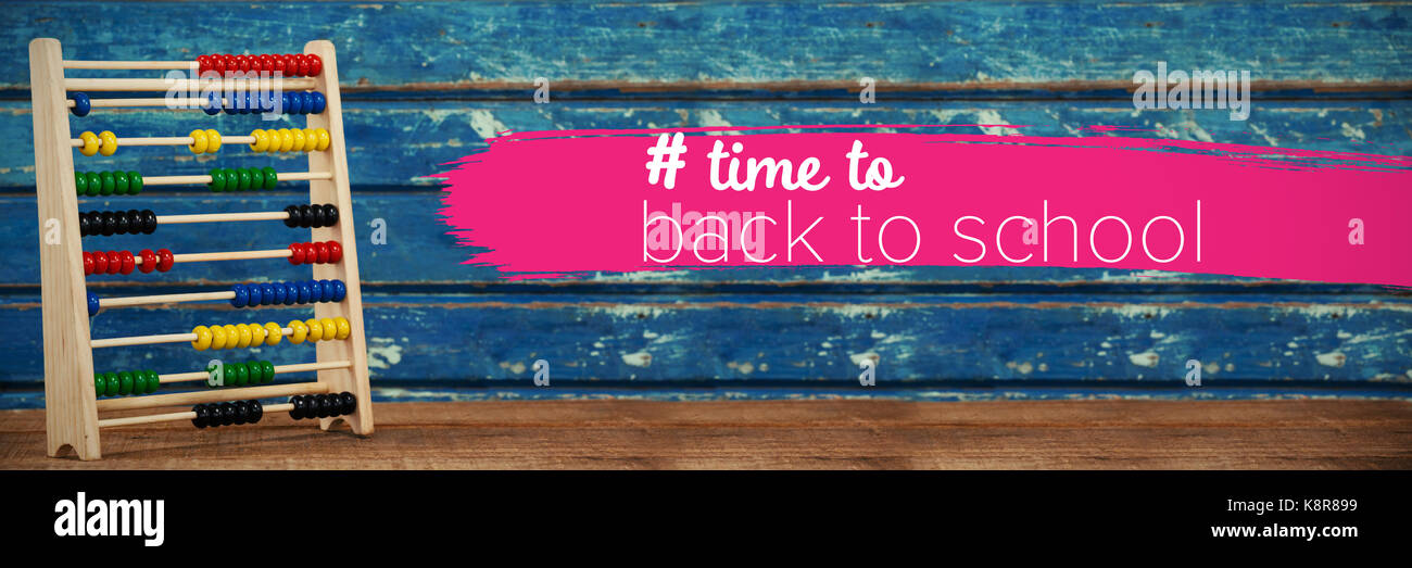 Back to school text with hashtag against multi colored abacus on table ...