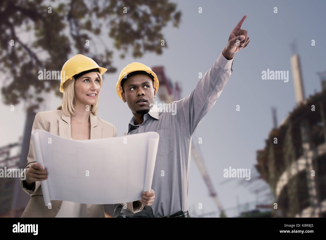 Man gesturing while standing with female architect against low angle ...