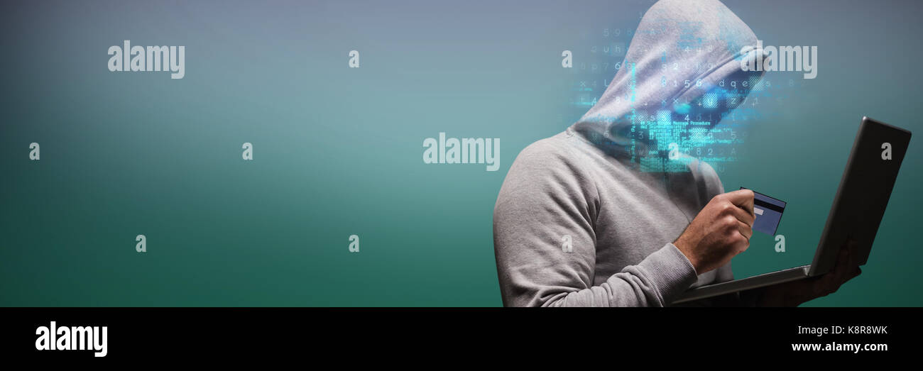 Hacker using laptop while holding credit card against turquoise and ...