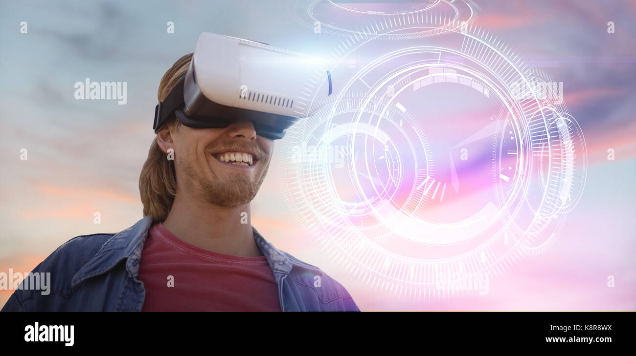 Smiling young man wearing virtual reality simulator against interface ...