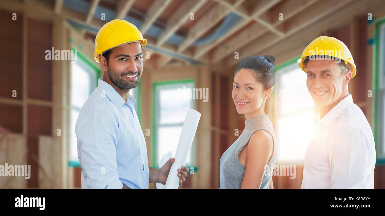 Portrait of architect holding blueprints against house under ...