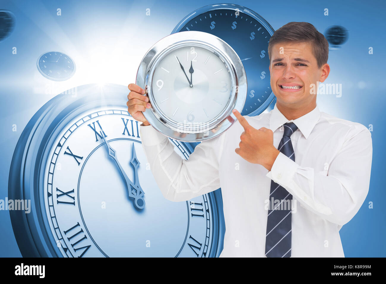 Anxious Businessman Holding And Showing A Clock Against Computer