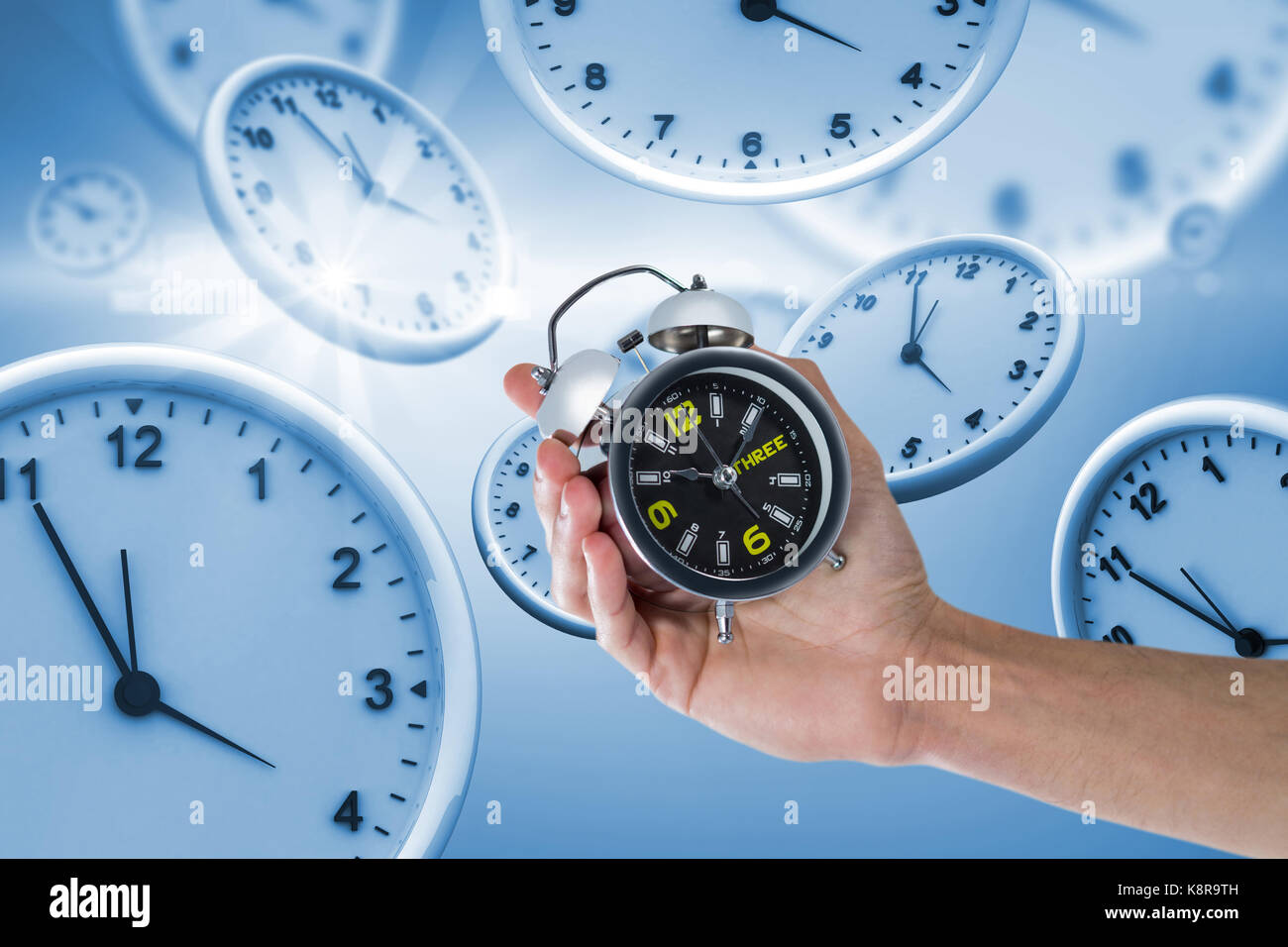 Cropped Hand Of Man Holding Alarm Clock Against Computer Graphic Image