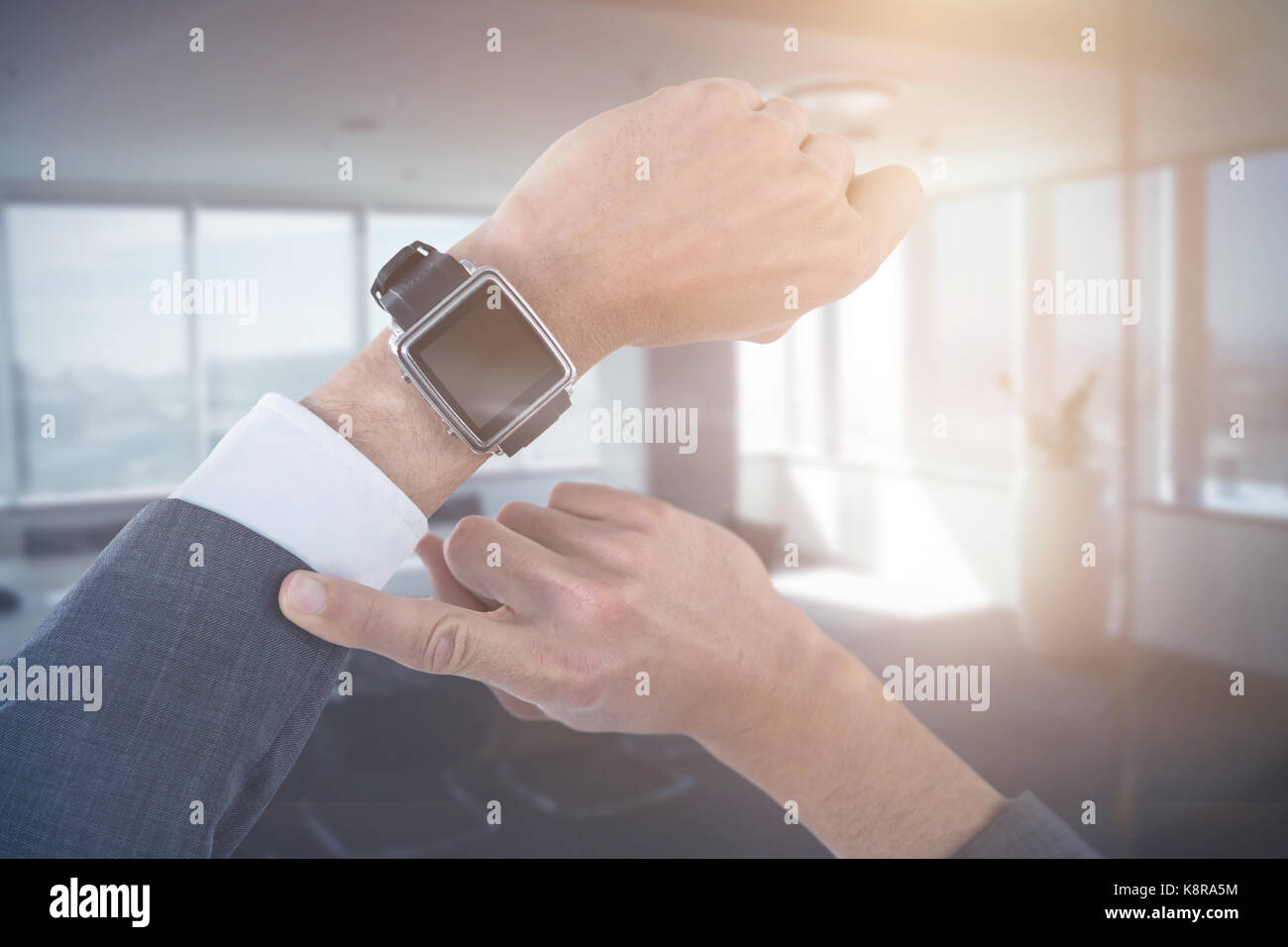 Cropped hand of businessman wearing smart watch against empty chairs ...
